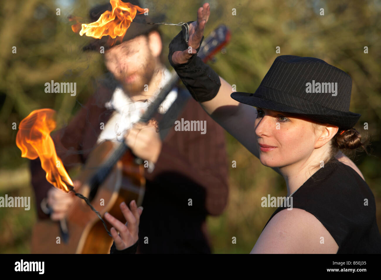 man playing guitar with firepoise woman fire dancer playing with fire ...