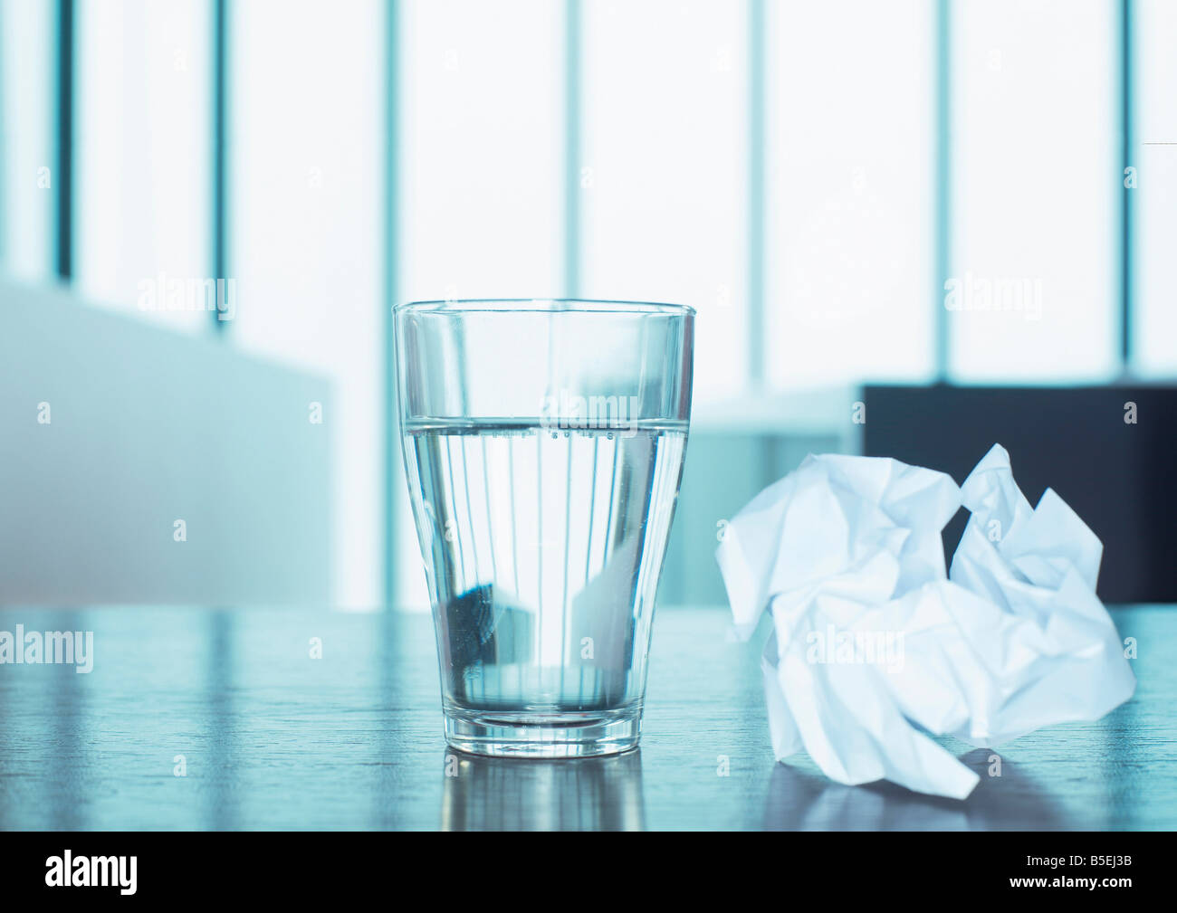 Crumpled sheet of paper beside a glass of water Stock Photo - Alamy