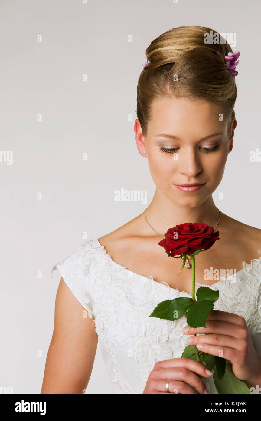 Young bride holding a rose, portrait Stock Photo - Alamy