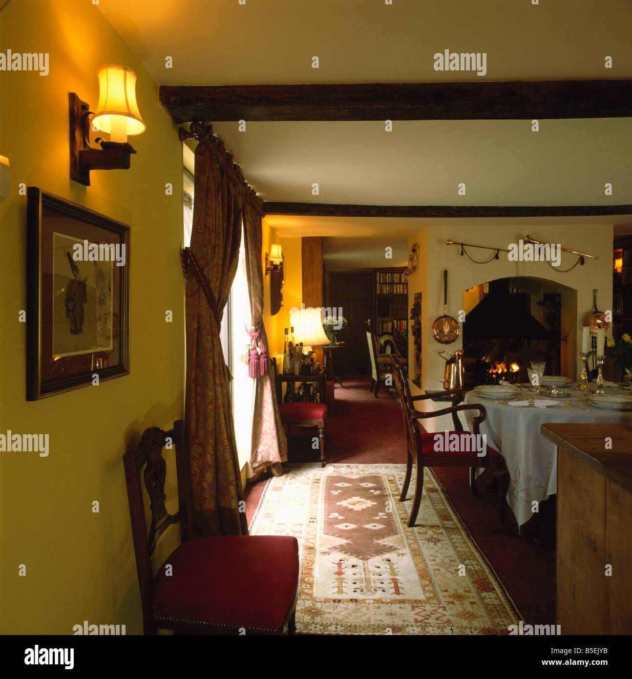 Lighted wall lamps and patterned rug in cottage dining room Stock Photo ...