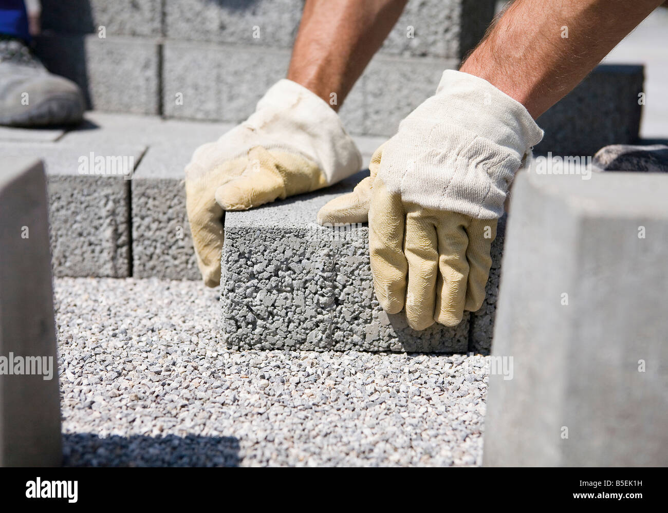 Construction worker setting paving stone Stock Photo - Alamy