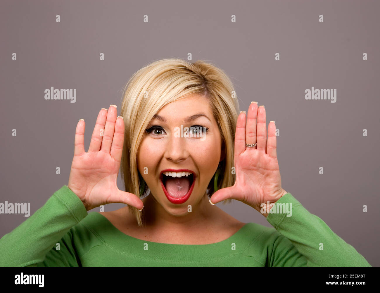 A blonde yelling toward camera with her hands up for emphasis Stock ...