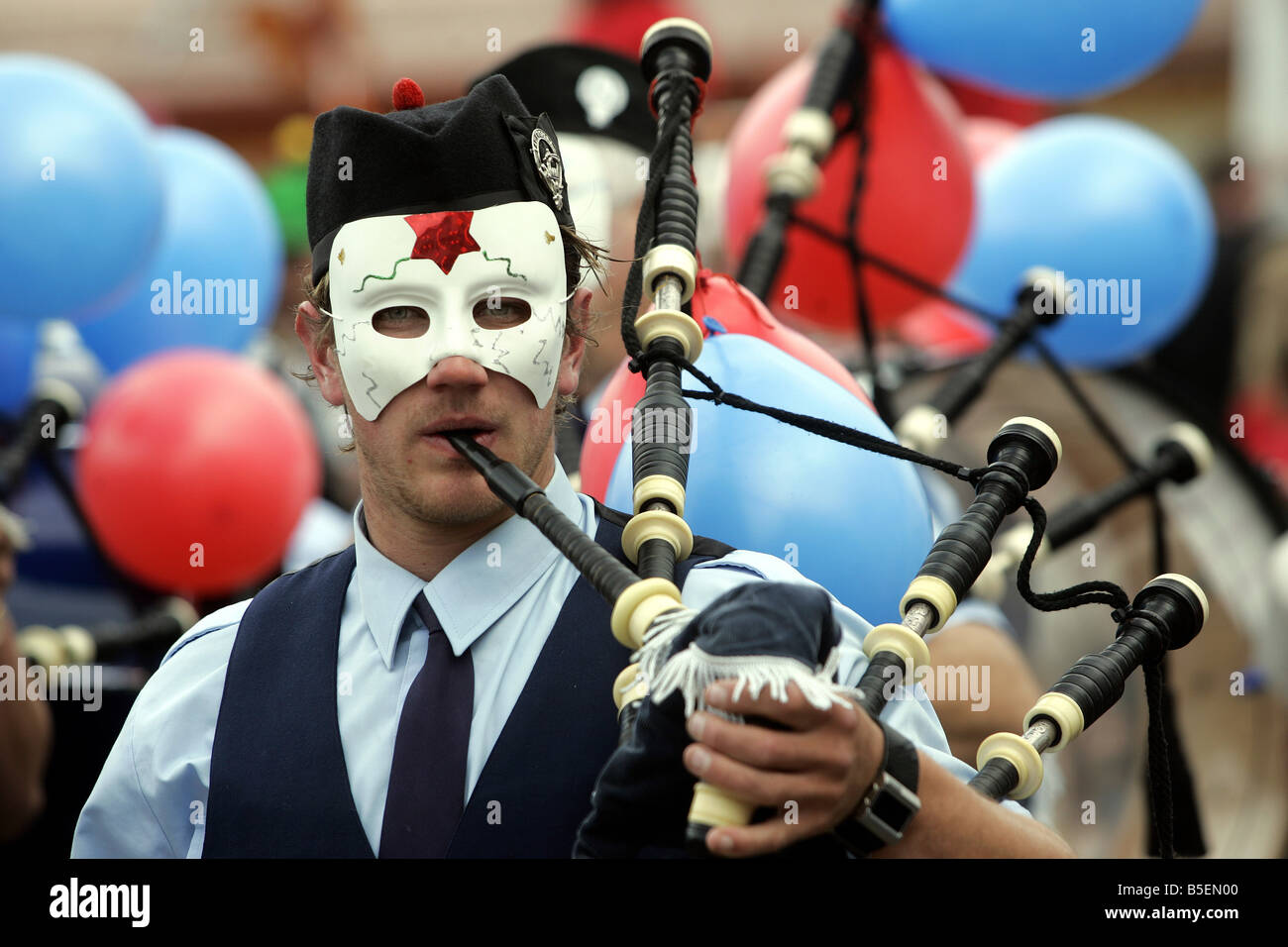 a piper in the Nelson masked parade Stock Photo - Alamy