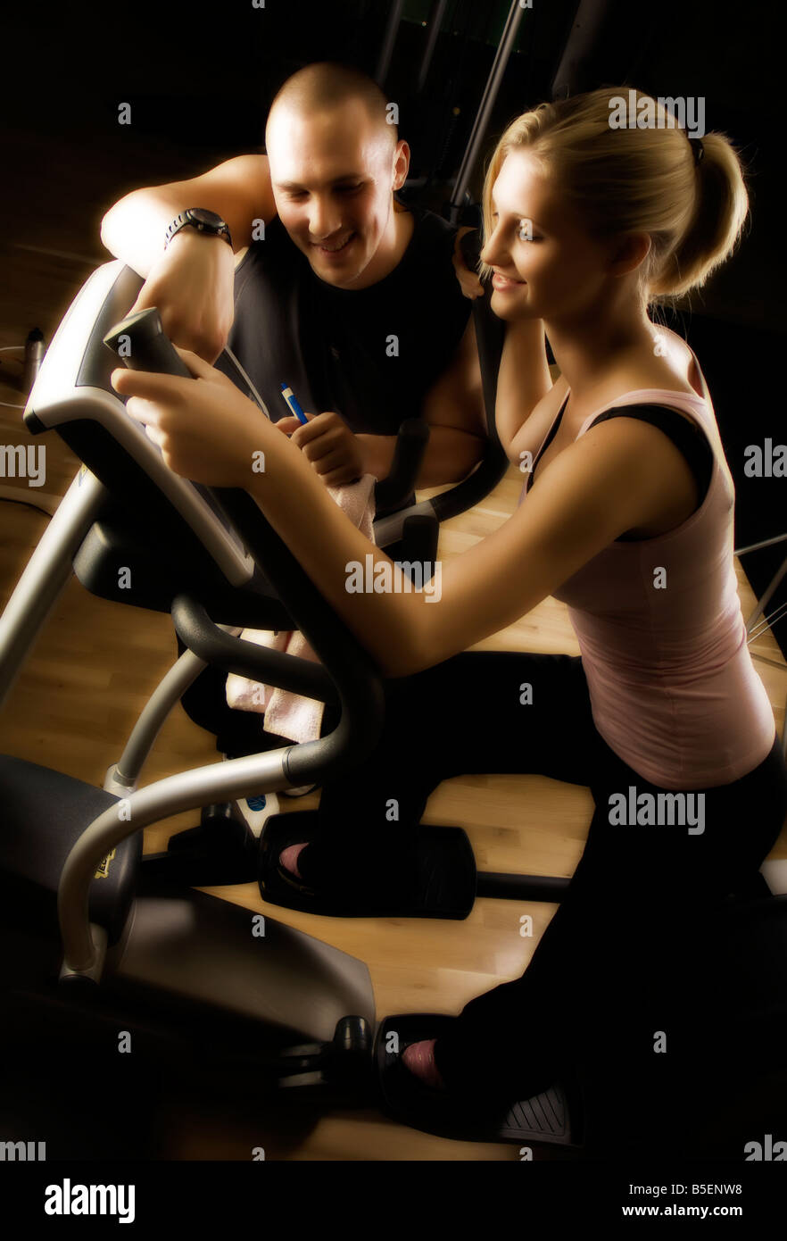 trainer with young woman on Stairmaster Stock Photo - Alamy