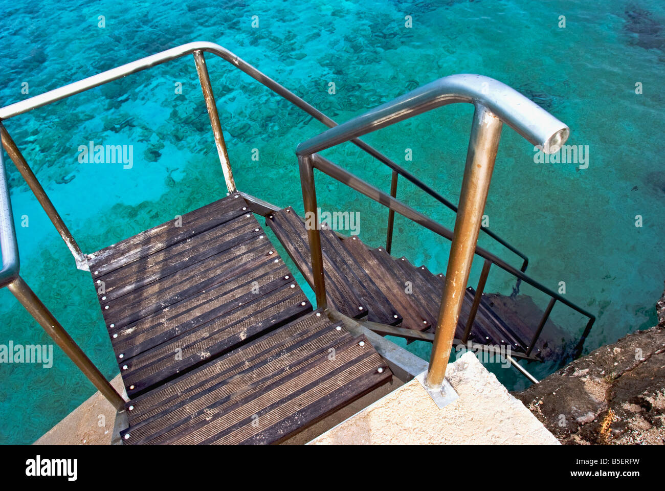 wooden and stainless steel steps leading down to tropical sea Stock ...