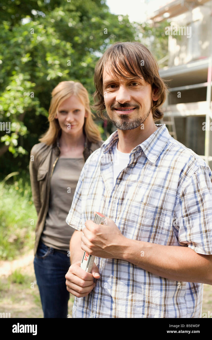 Young couple, man holding folding rule, smiling, portrait Stock Photo ...