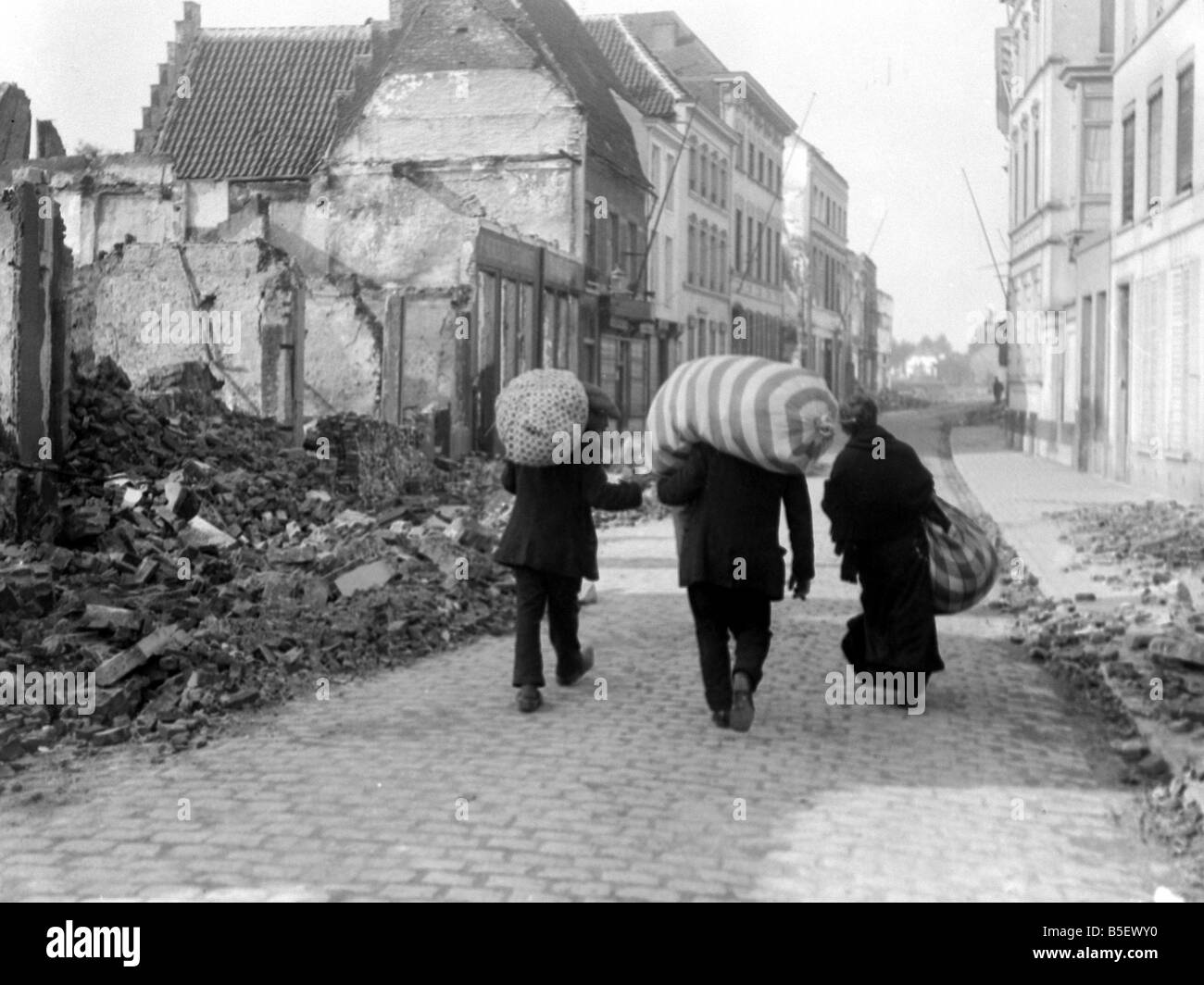 Refugees carry their belongings with them as they flee the fighting ...