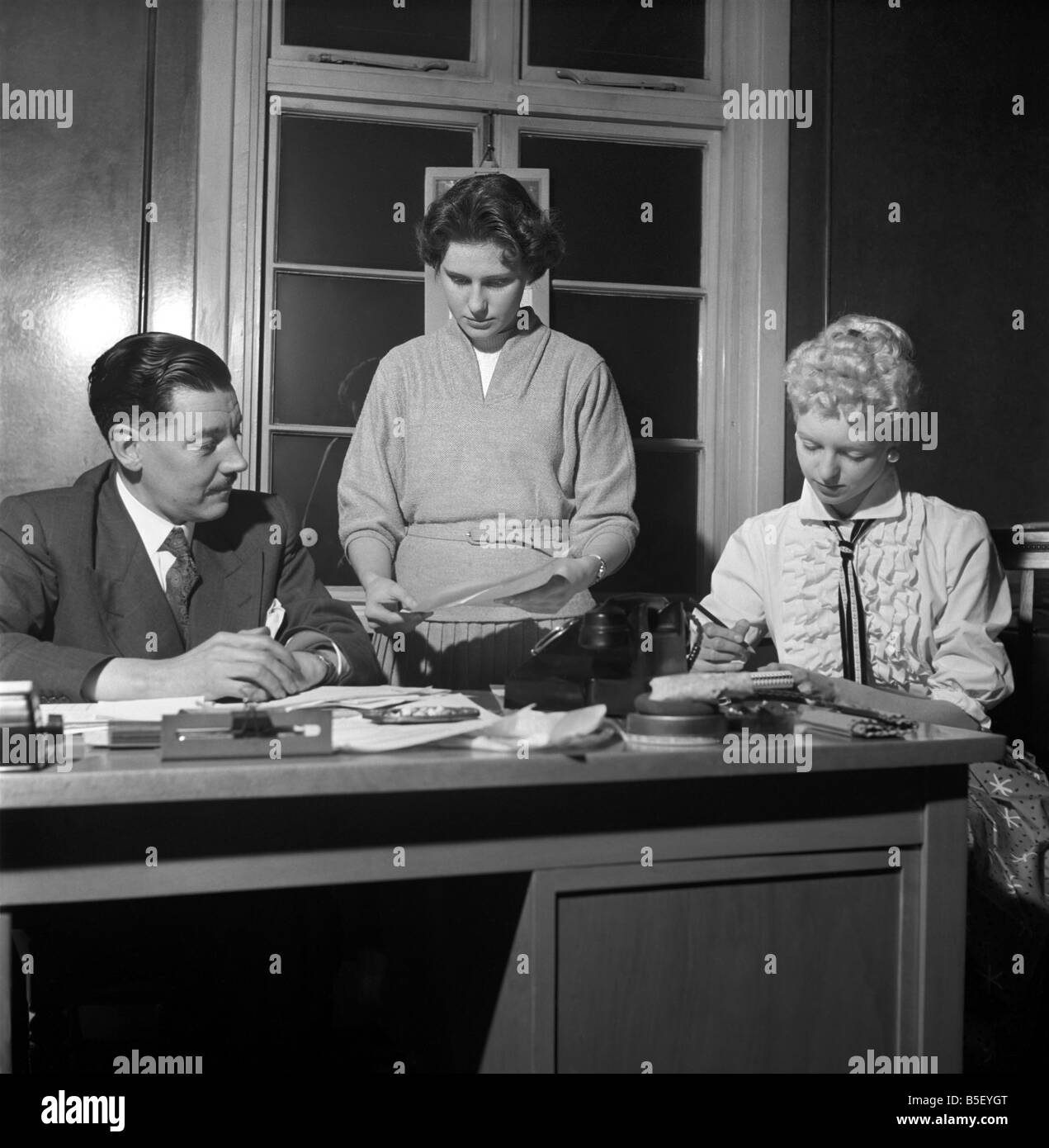 General office scene: Secretary taking notes and answering the phone in ...