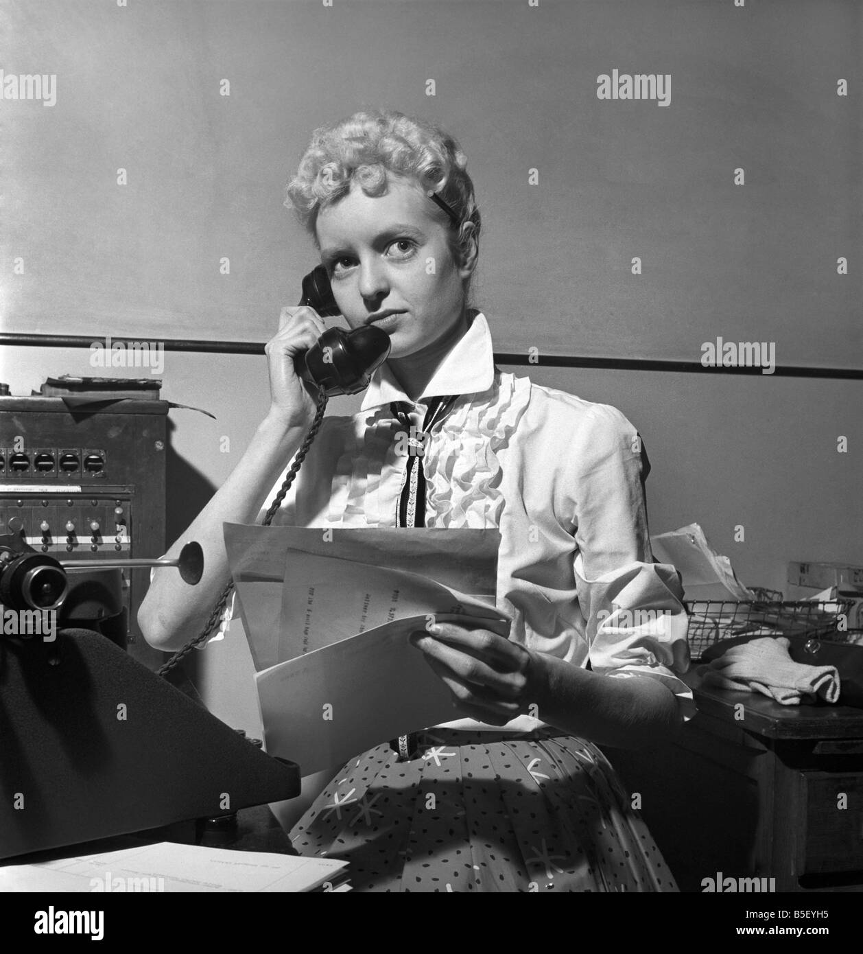 General office scene: Secretary taking notes and answering the phone in ...
