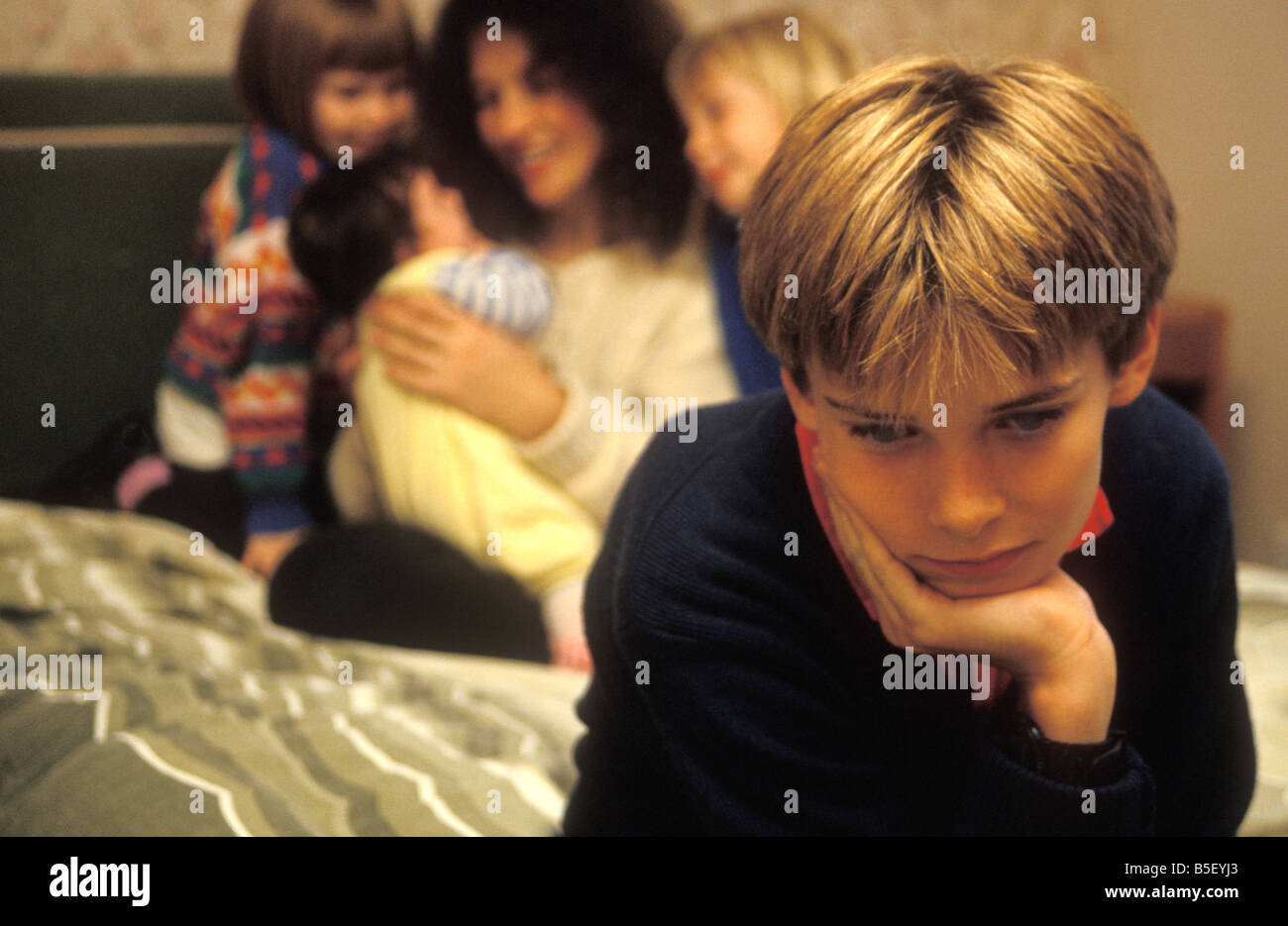 moody boy feeling isolated from family members who are making fuss of ...