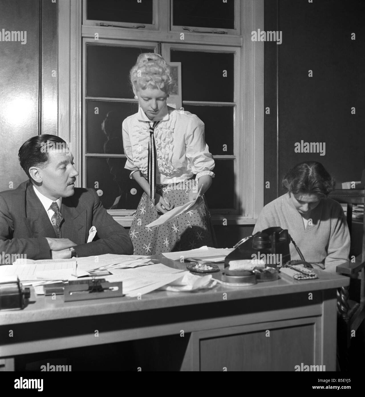 General office scene: Secretary taking notes and answering the phone in ...