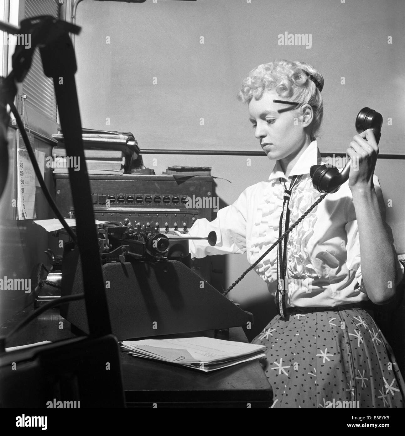 General office scene: Secretary taking notes and answering the phone in ...