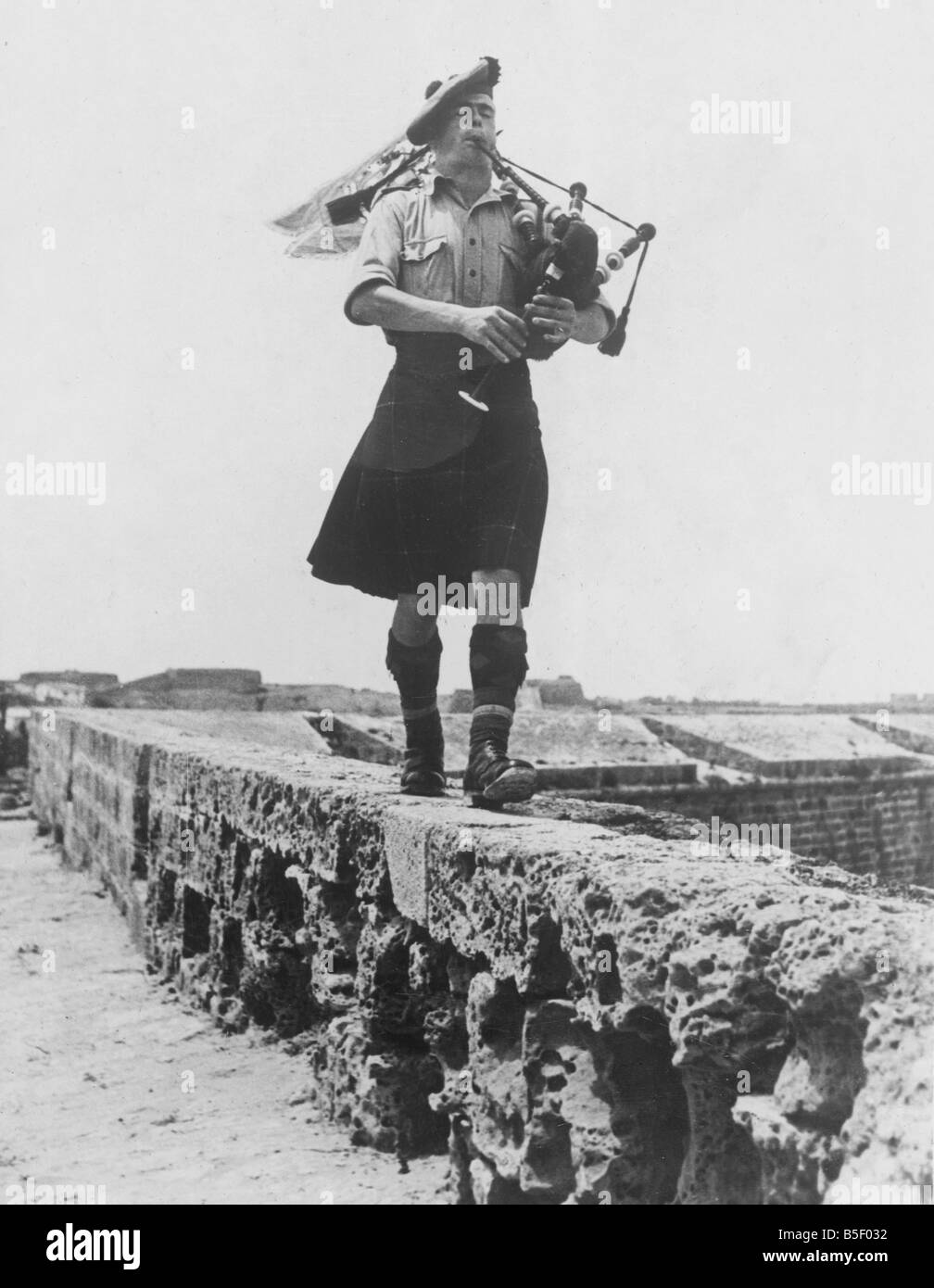A Highland piper on duty one of the crusader's ancient battlements on ...