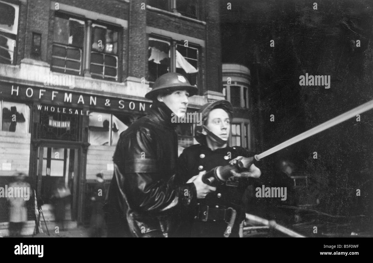 Two firefighters attempt to put out the flames of a fire during the ...