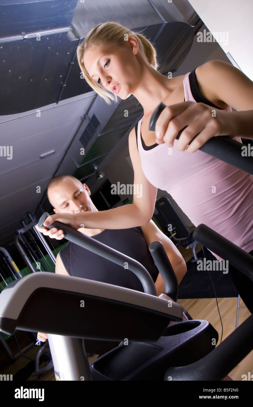 trainer with young woman on Stairmaster Stock Photo - Alamy