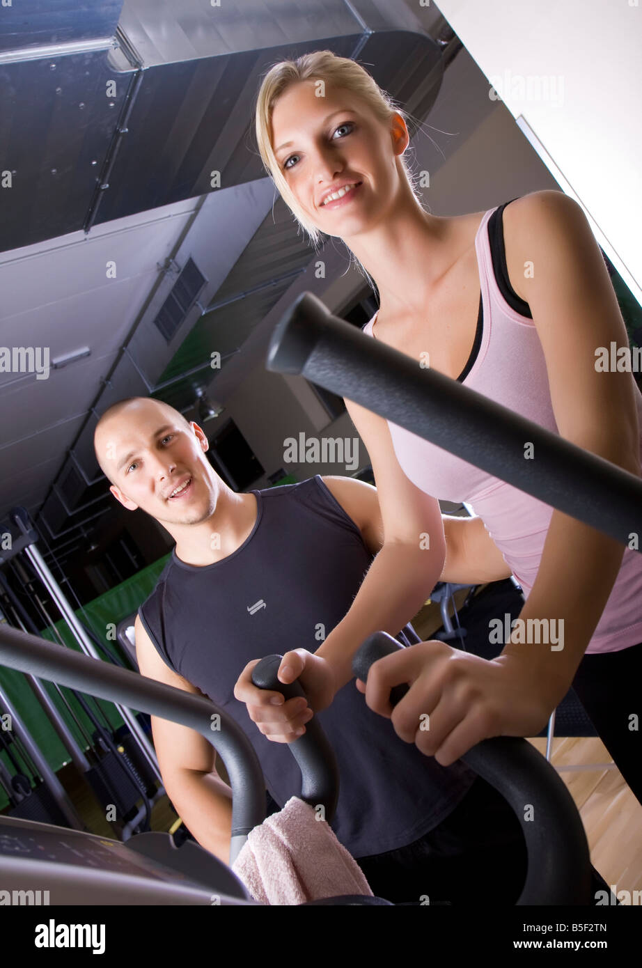 trainer with young woman on Stairmaster Stock Photo - Alamy