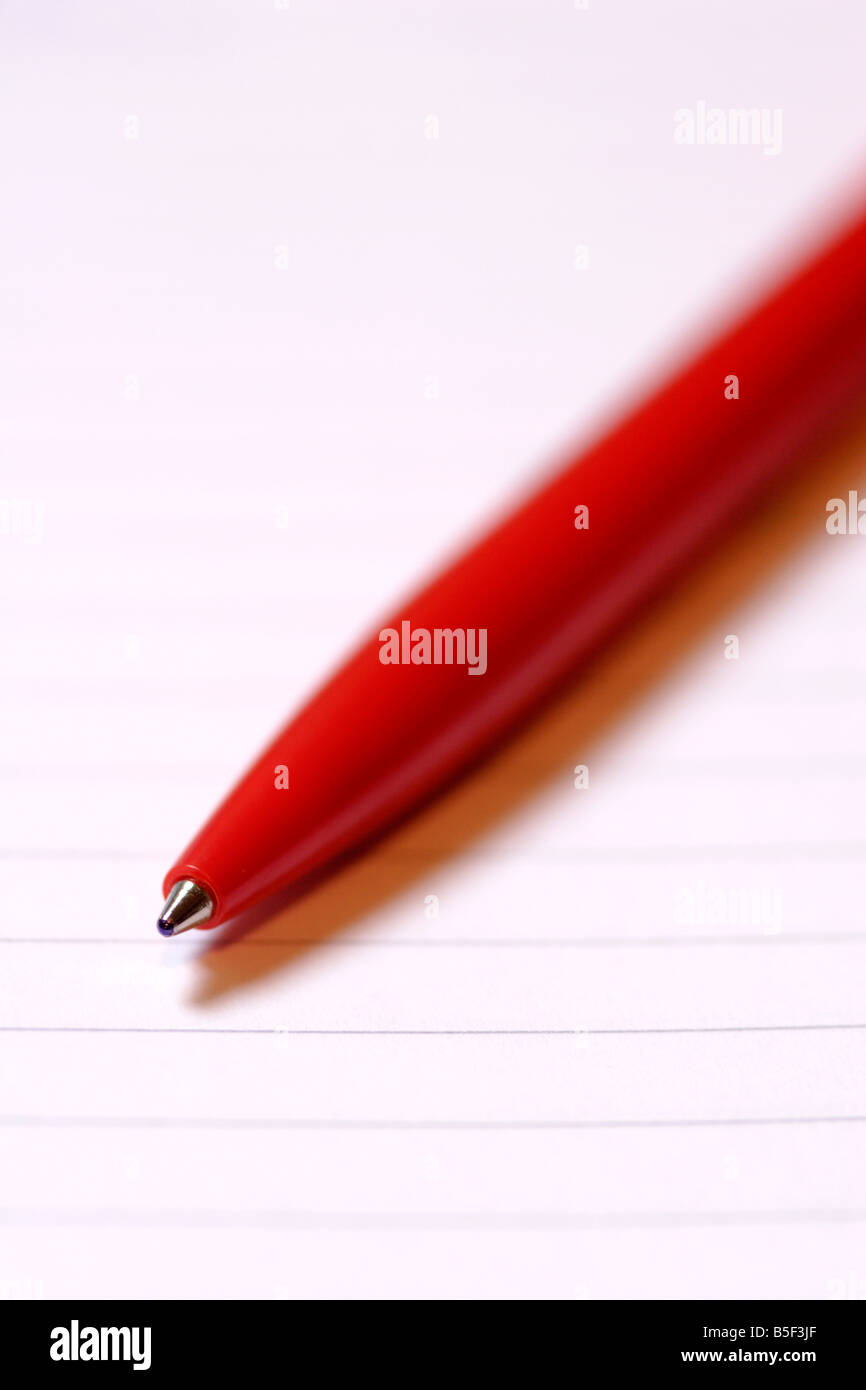 Red biro pen on lined paper close up Stock Photo - Alamy