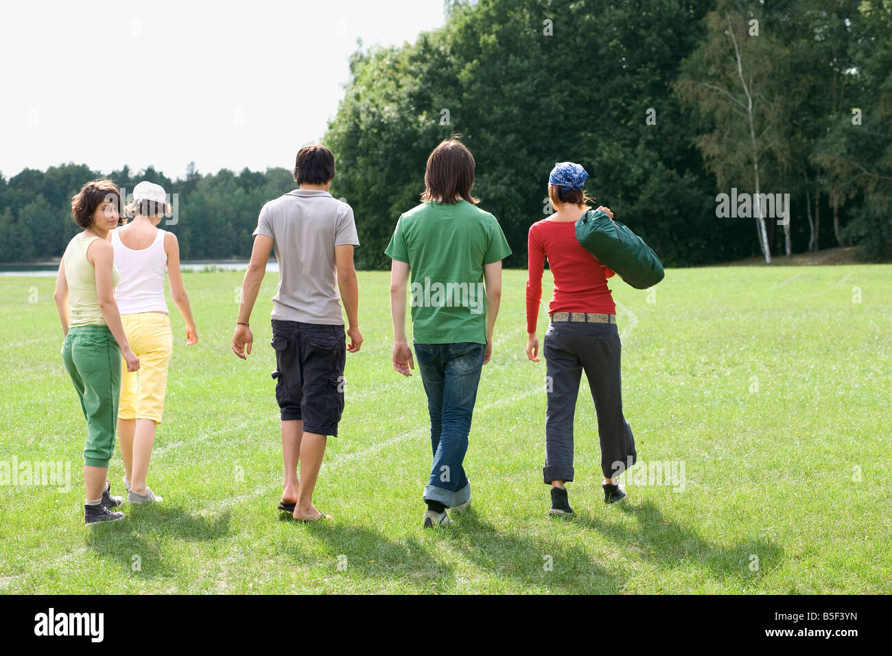 Germany, Friends walking on grass Stock Photo - Alamy