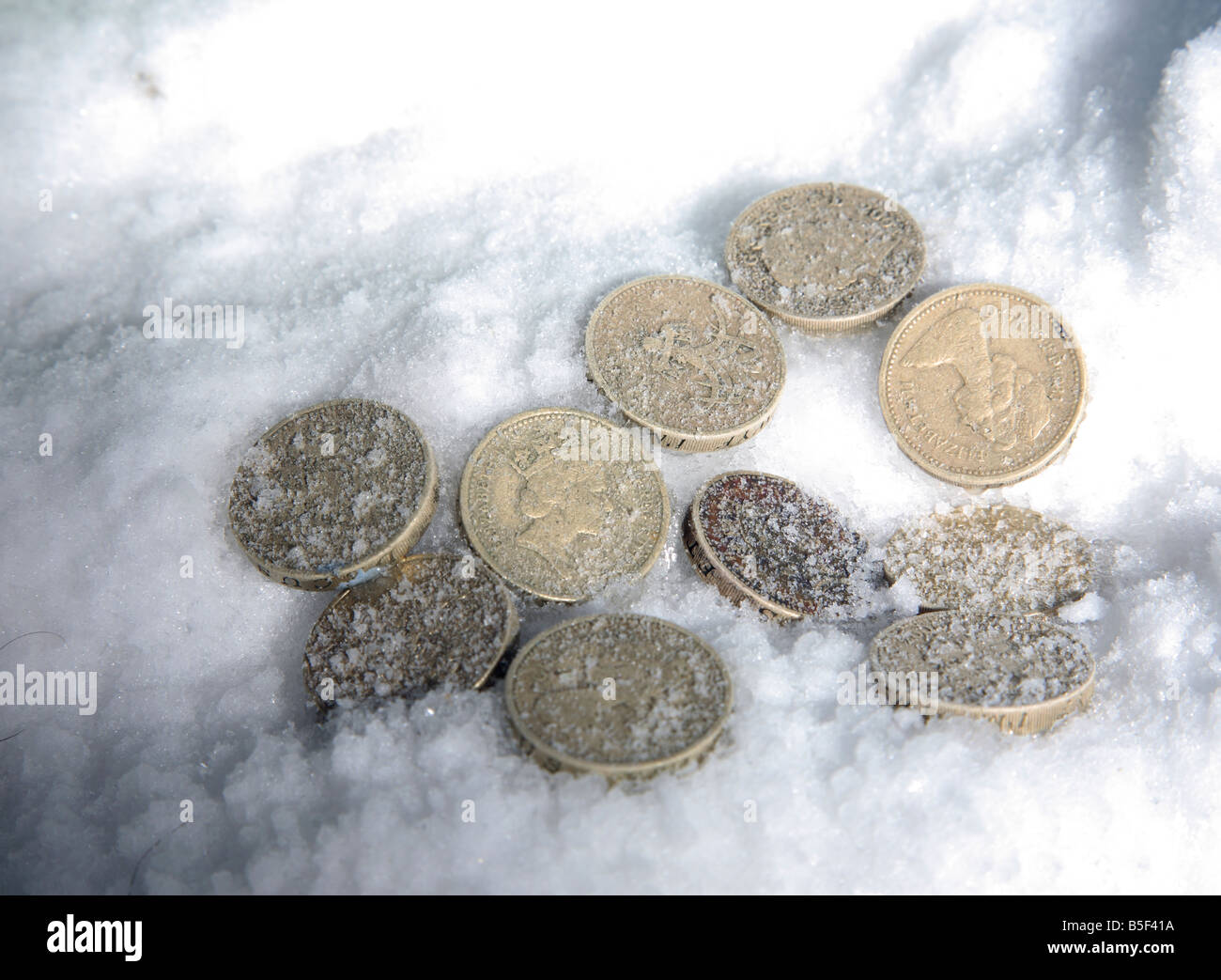 Pound sterling coins frozen in ice Stock Photo - Alamy