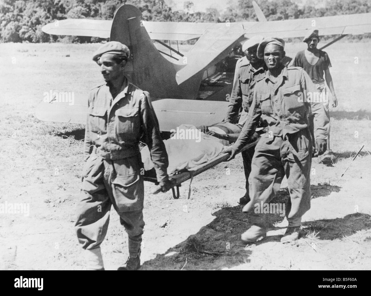 A wounded West African soldier is carried on a stretcher by soldiers ...
