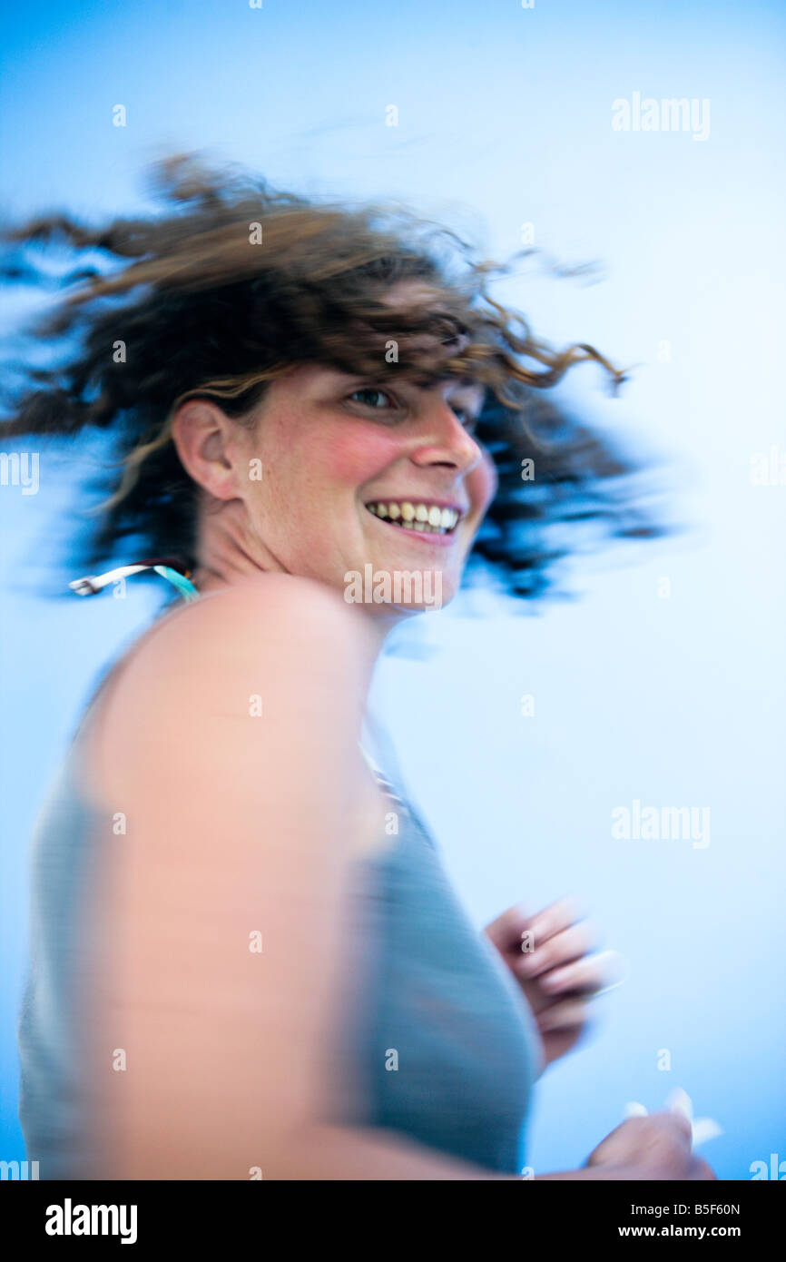 Happy smiling young woman against blue background Stock Photo - Alamy
