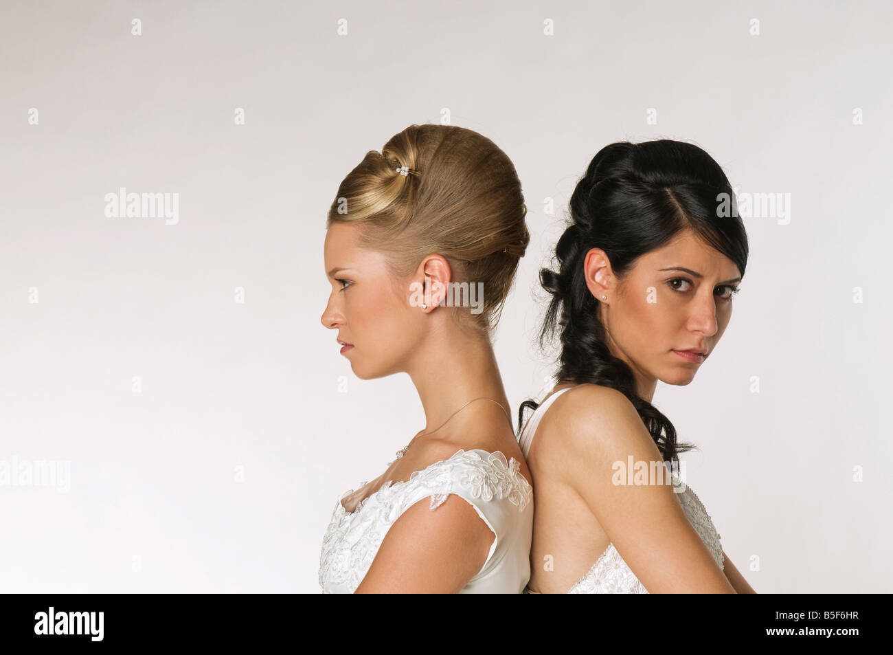 Young brides standing back to back, portrait Stock Photo - Alamy