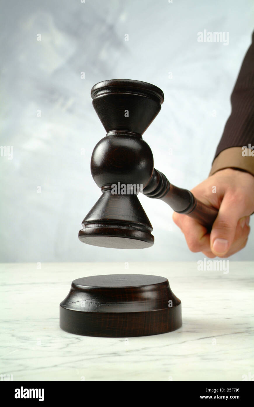 A hand holding an auction hammer Stock Photo - Alamy