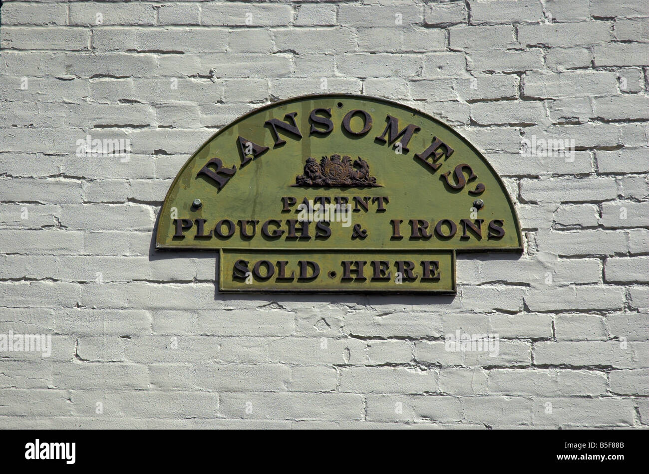 A sign on a wall for Ransomes patent Ploughs and Irons Sold Here in ...