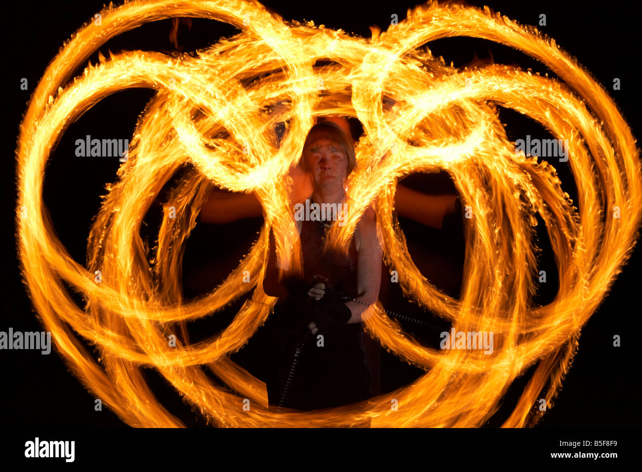 firepoise two female fire dancers dance with poi flames during ...
