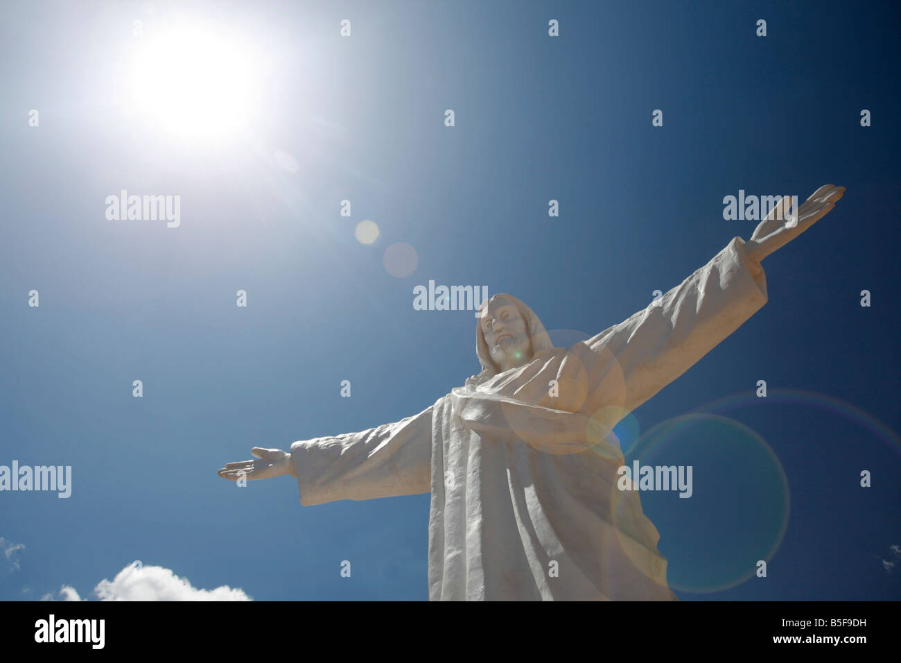 Statue of Jesus with sun flare and blue sky Stock Photo - Alamy