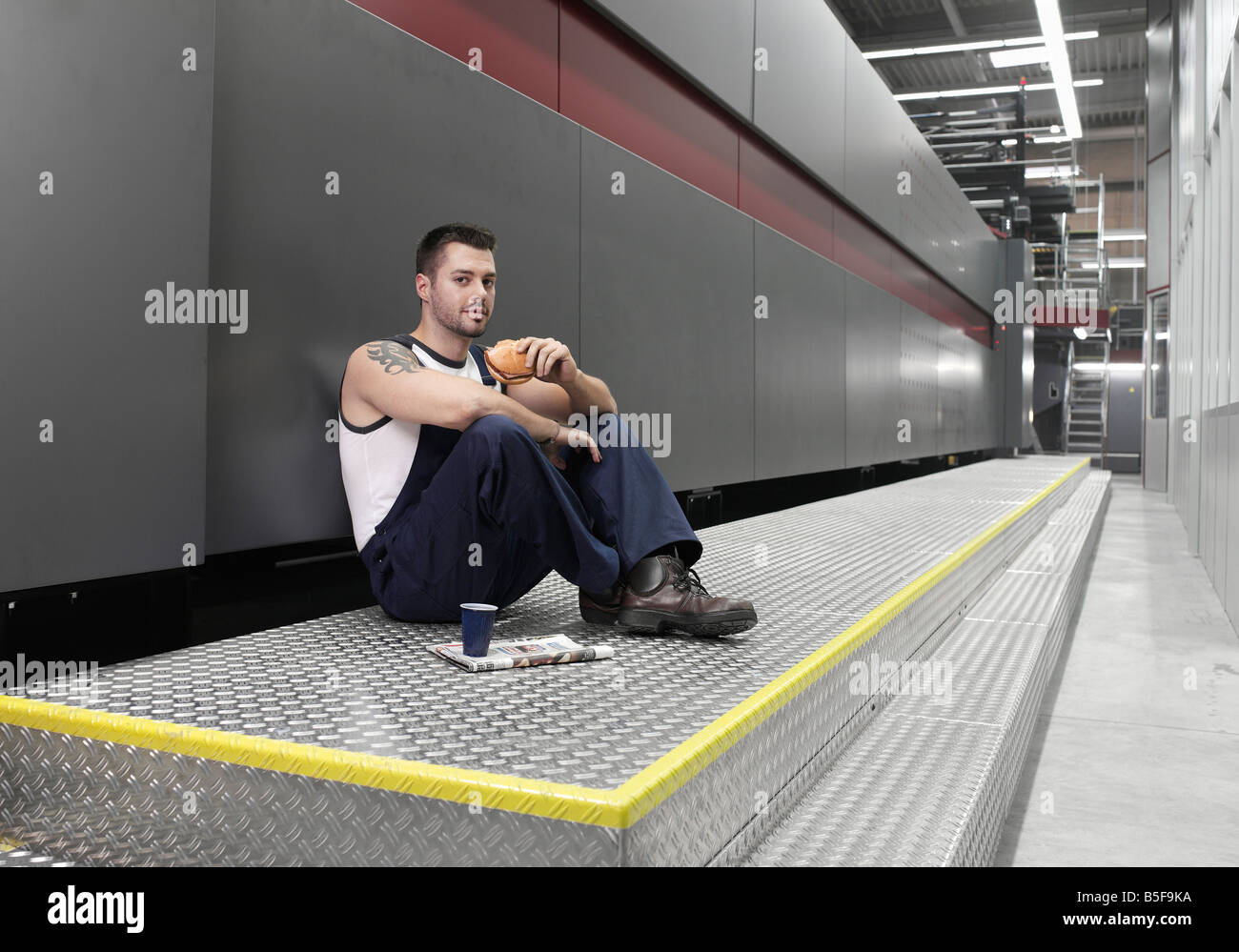 Worker sitting in printing company Stock Photo - Alamy