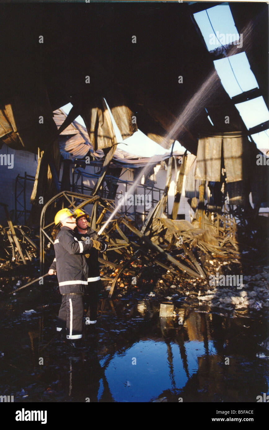 Firefighters get the warehouse fire under control Stock Photo - Alamy