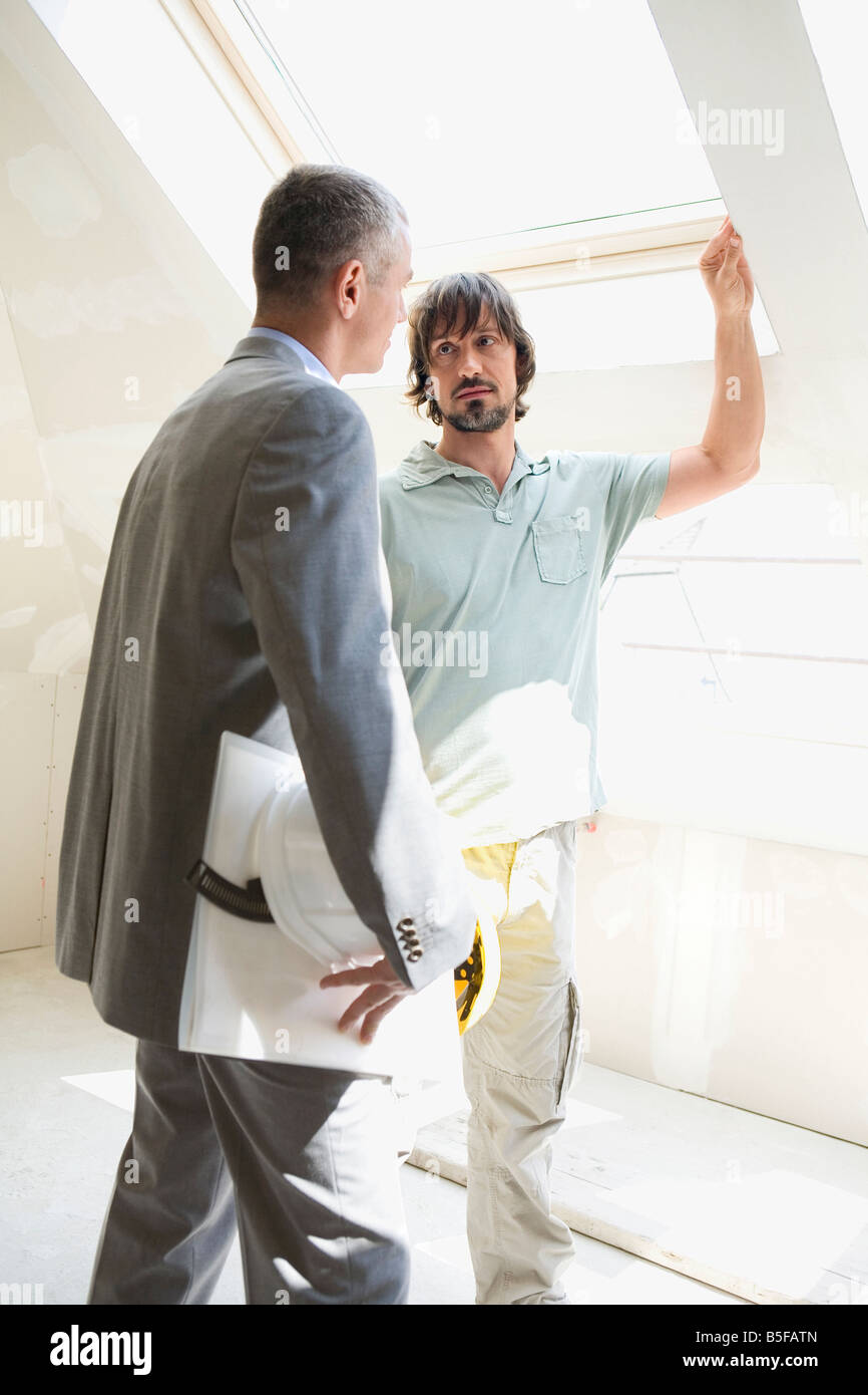 Two men talking at construction site Stock Photo - Alamy