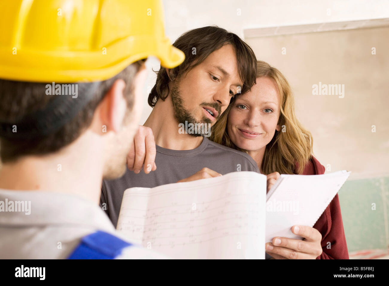 Construction worker and young couple Stock Photo - Alamy