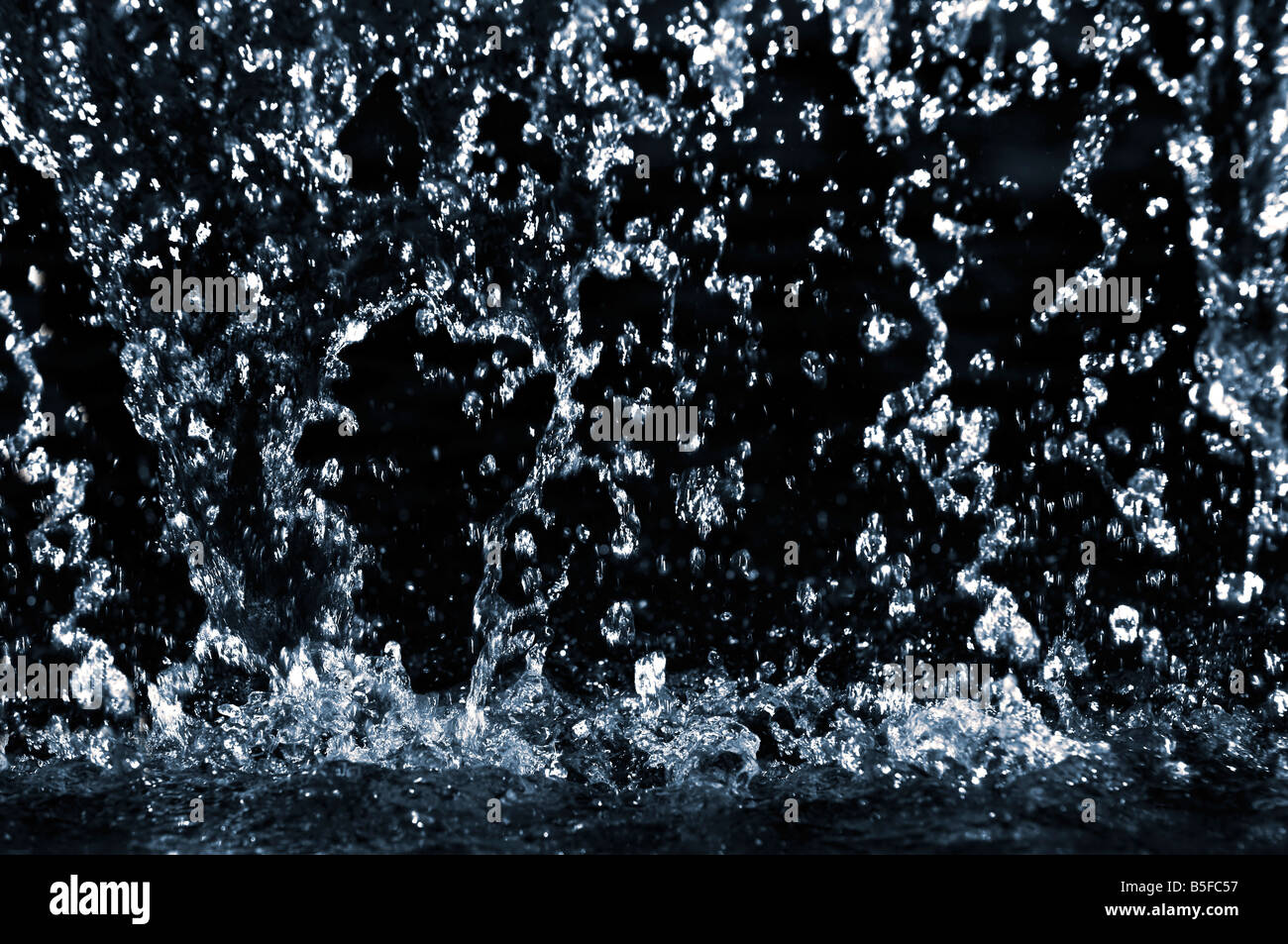 Falling water drops on dark background close up Stock Photo - Alamy