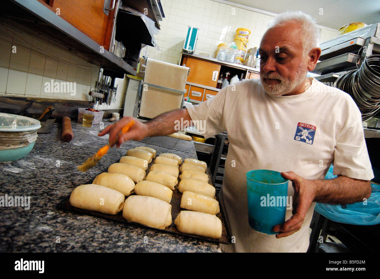 A French chef at work in his bakery, making croissants and other ...