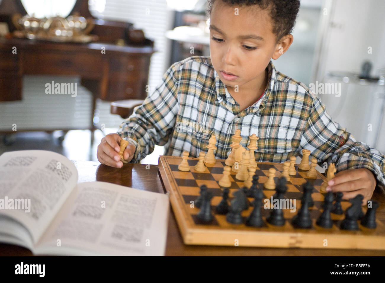 Young boy learning chess Stock Photo - Alamy