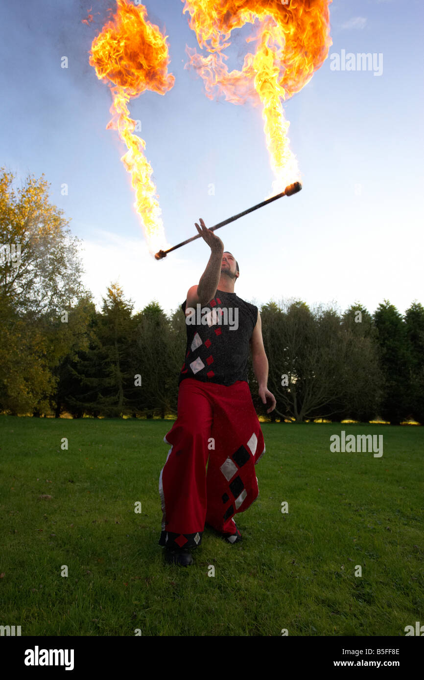 male performance artist playing with fire staff blowout during ...