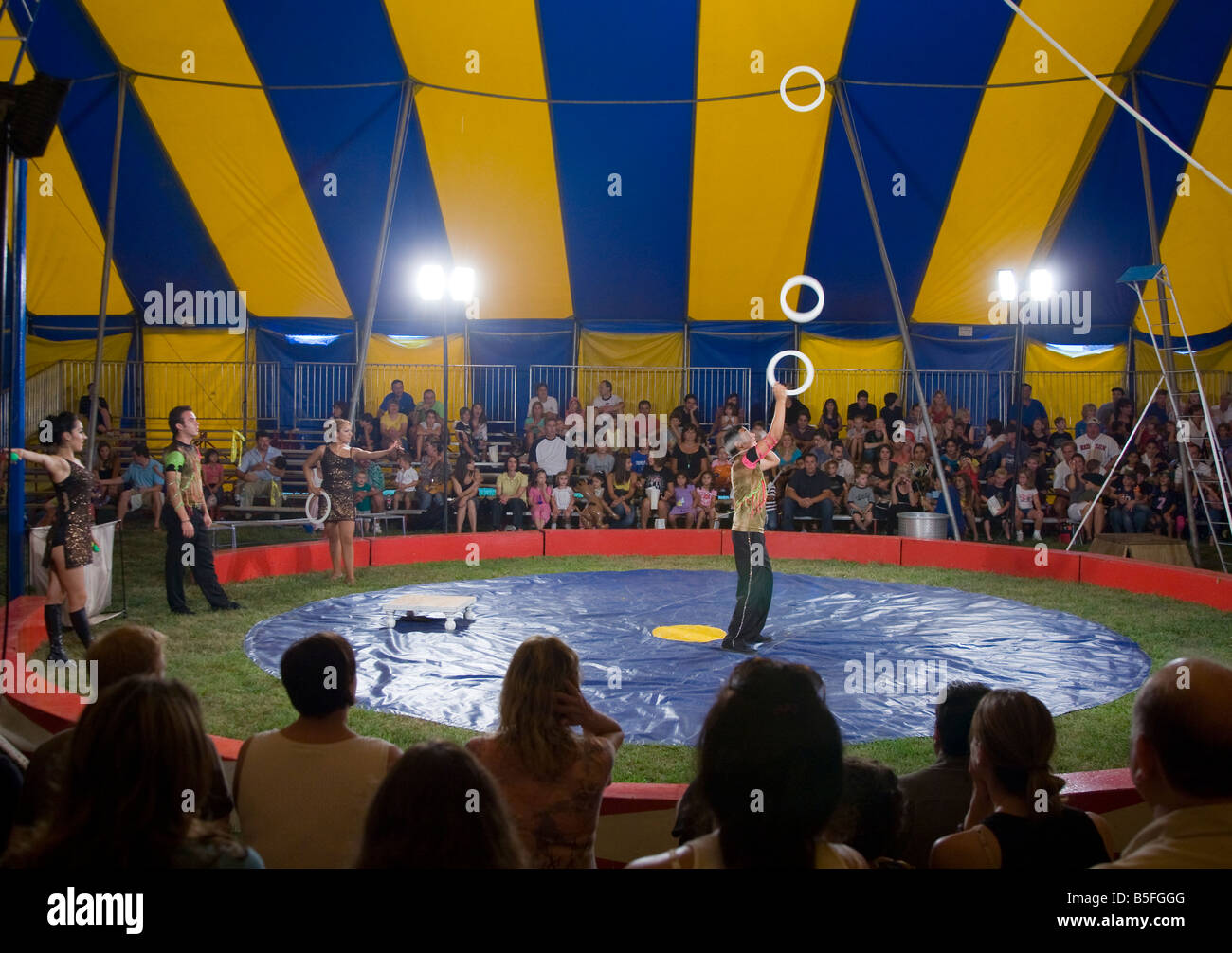 Circus performer juggling rings while audience watches Stock Photo - Alamy