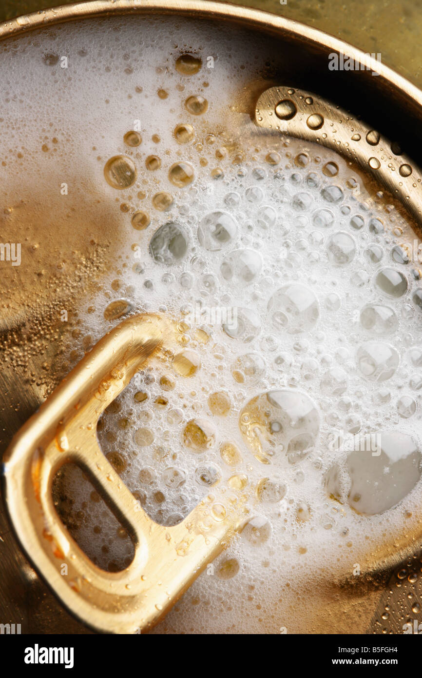 Opened beer can with froth close up Stock Photo - Alamy
