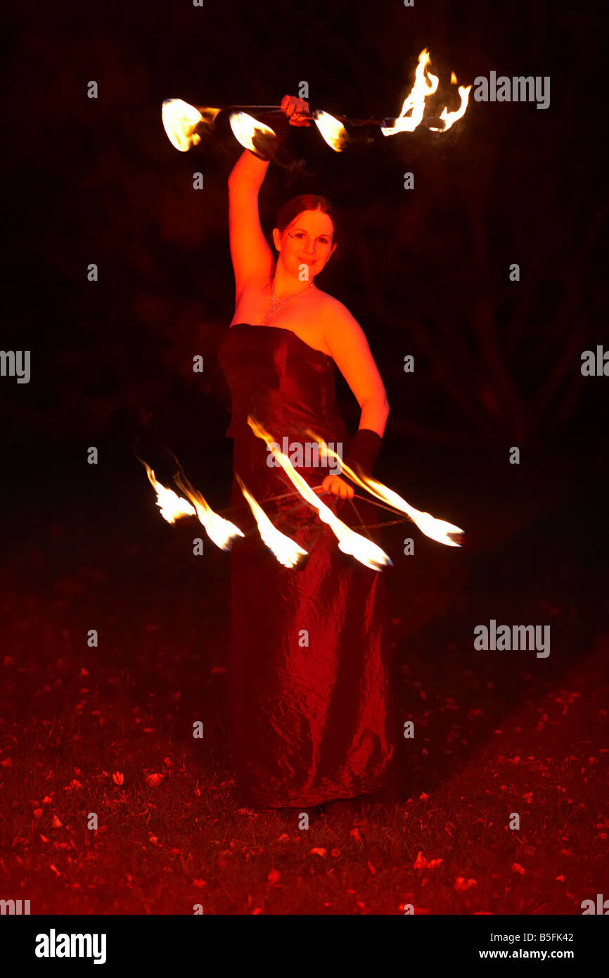 firepoise female fire dance performance artist holding fire fans at ...