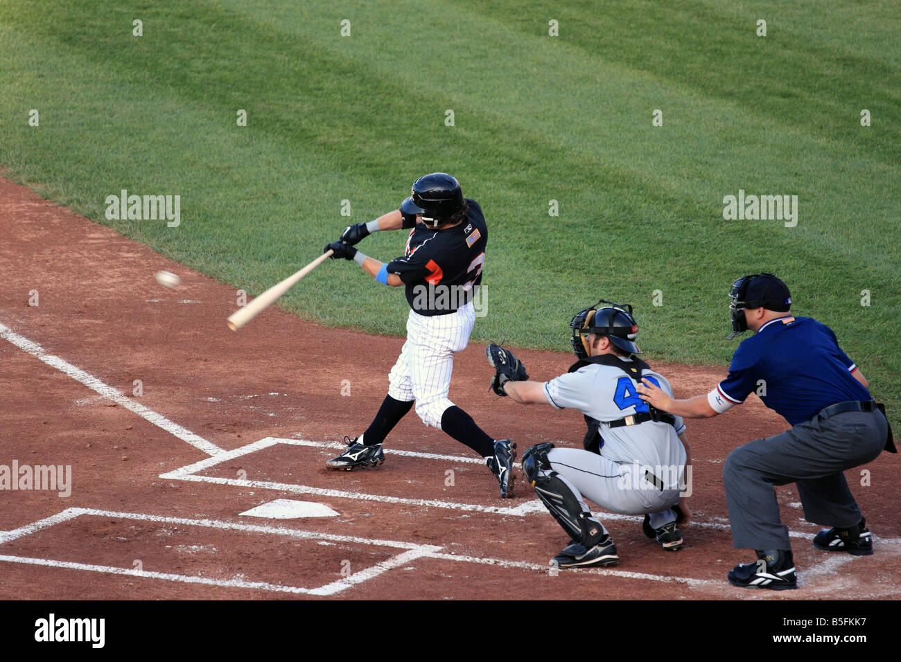 Erie Seawolves player hits the pitch while the catcher and umpire watch ...