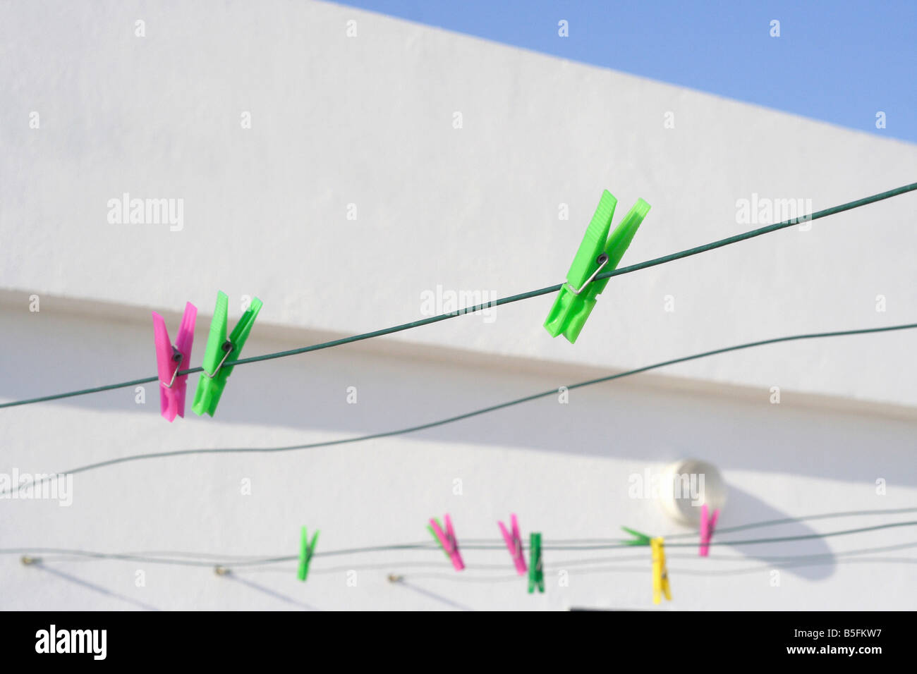 Colourful cloth pegs hanging on a wire Stock Photo - Alamy