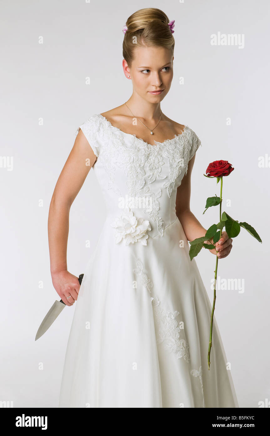 Young bride holding knife and rose, portrait Stock Photo - Alamy