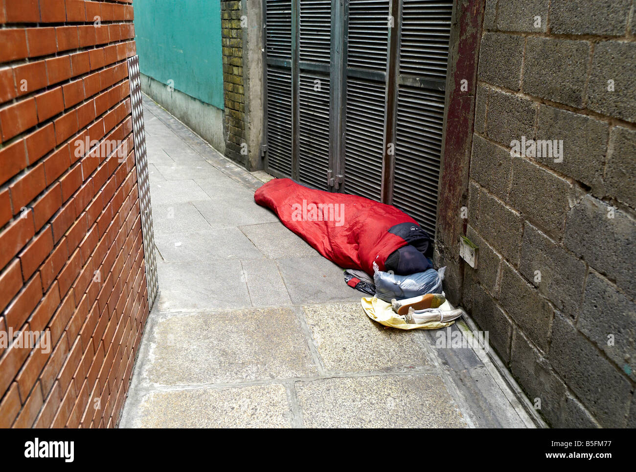 Homeless person asleep in a sleeping bag up an alleyway in Dublin ...