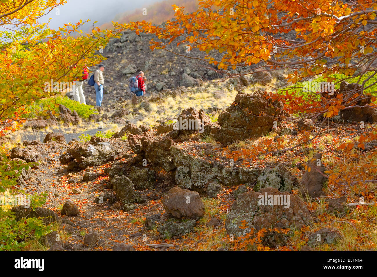 Hikers in the autumn landscape of Etna volcano Stock Photo - Alamy