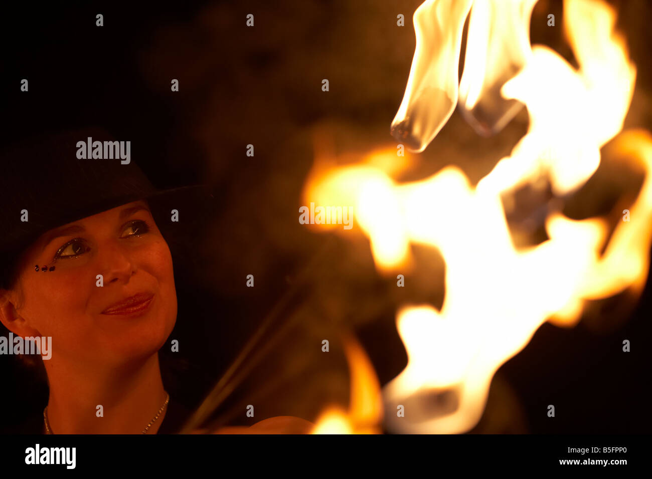 firepoise female fire dance performance artist wearing hat holding fire ...