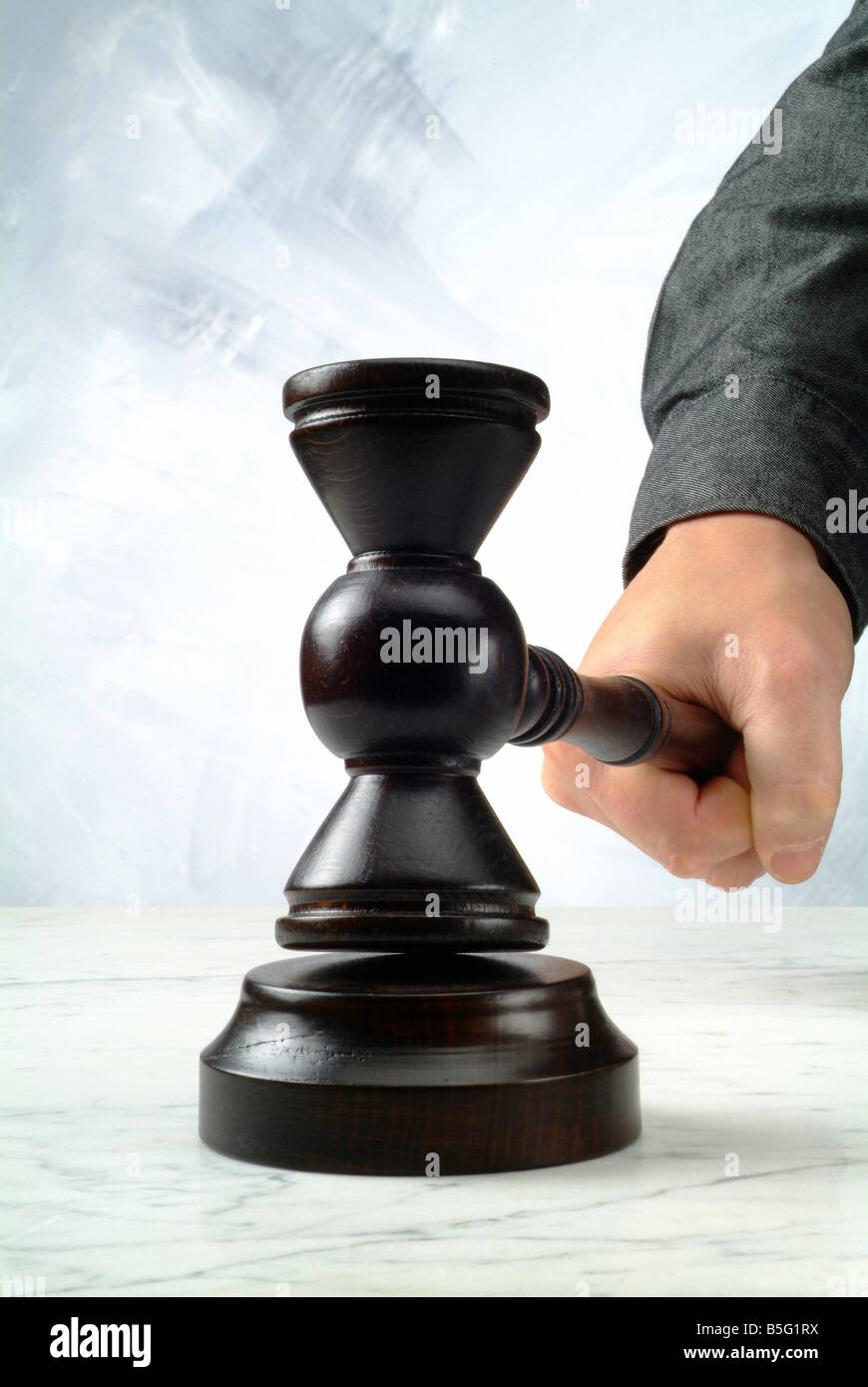 A hand holding an auction hammer Stock Photo - Alamy