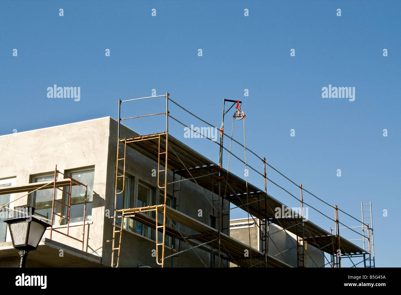 Scaffold and pulley on the front of a concrete building Stock Photo - Alamy
