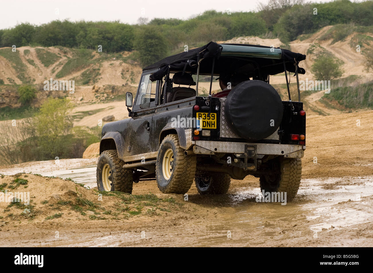 Rear view of a Land Rover defender driving off road in the uk Stock ...